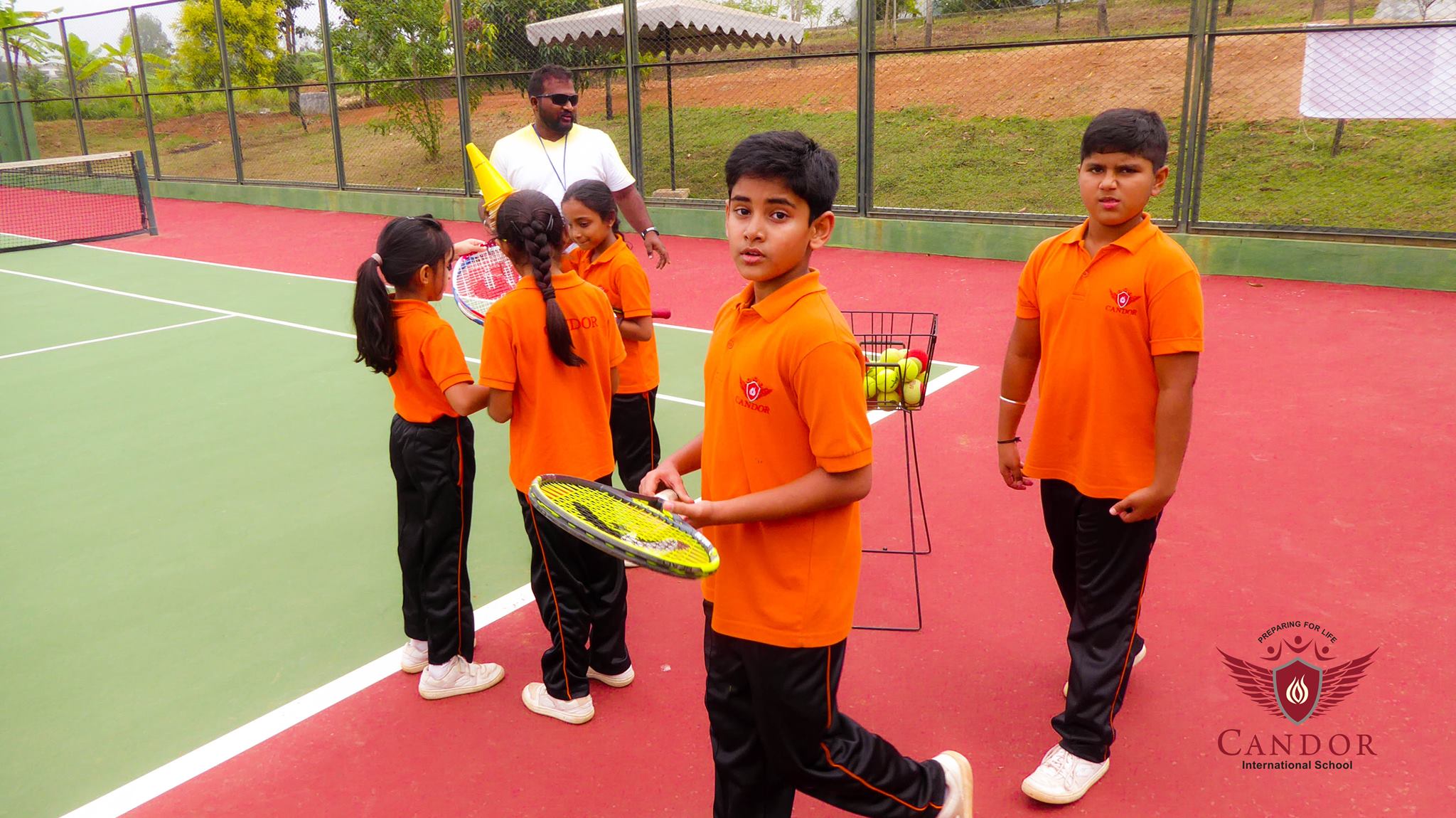 Grade 4 students learning to play Tennis. - Candor International School